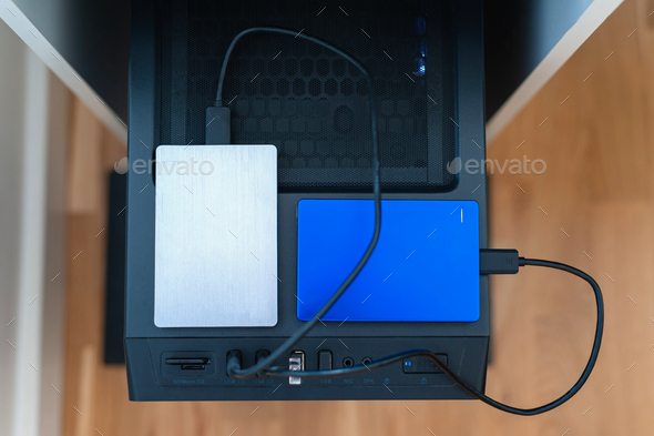 Two external SSD hard drivers connected to stationery computer in home ...
