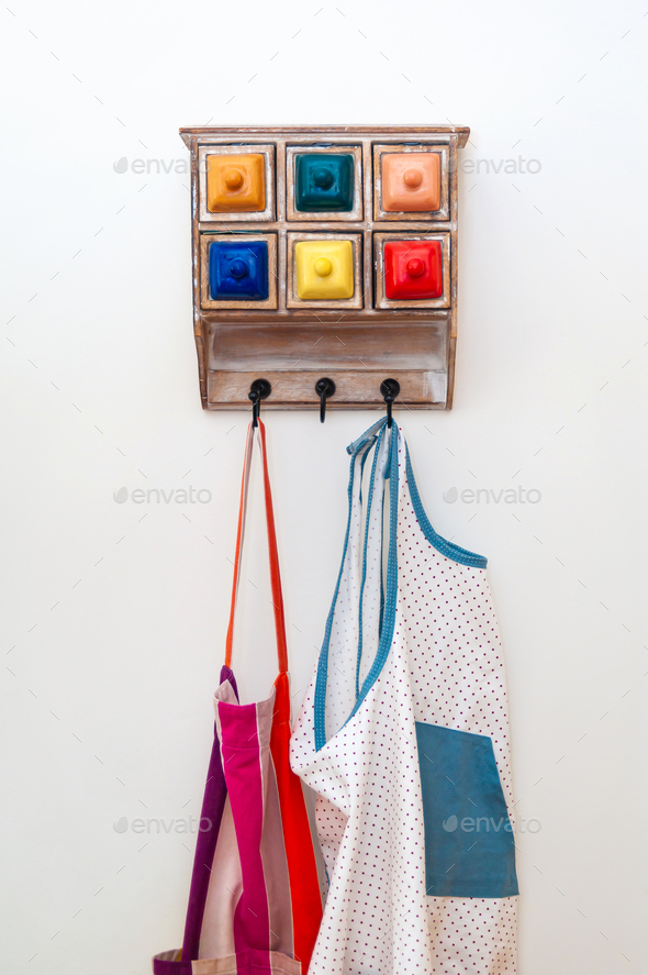 Vintage clothes hanger with small colorful square drawers on white wall ...