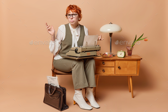 Displeased redhead office secretary dressed formally types on ...