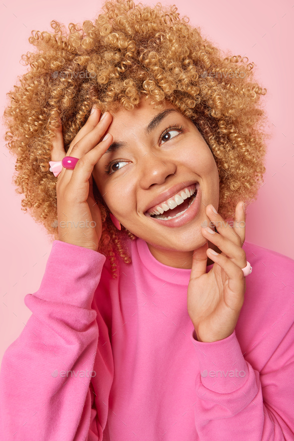 Happy authentic woman smiles broadly shows white teeth touches face ...