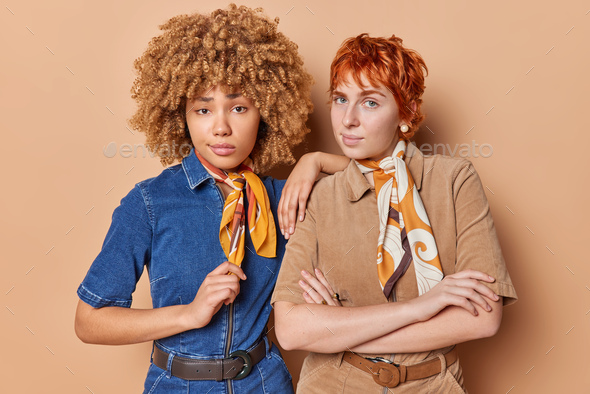 Studio shot of good looking young female models friends stand next to ...