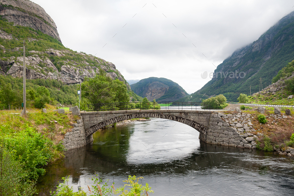 Little stone bridge across river. Open road. Empty road with no traffic ...