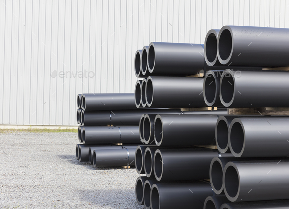 Stacks of industrial PVC pipes piled up outside a manufacturing ...