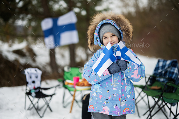 Finnish little girl with Finland flags on a nice winter day. Nordic ...