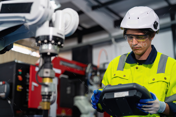Automation Engineer hold remote control prepare for test robotic arm ...