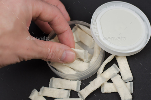 Man's hand takes a bag of Swedish snus on a black background Stock ...