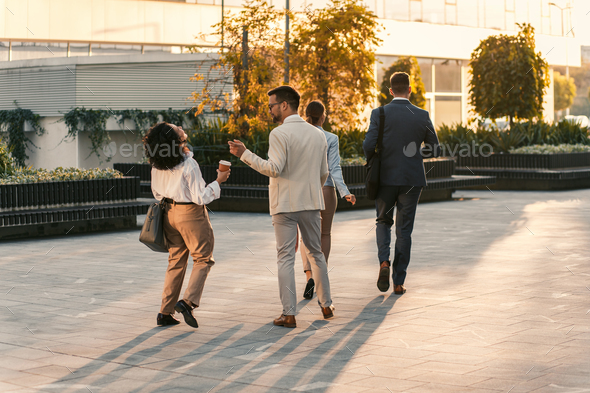 Group of business people walking outside in front of office buildings ...