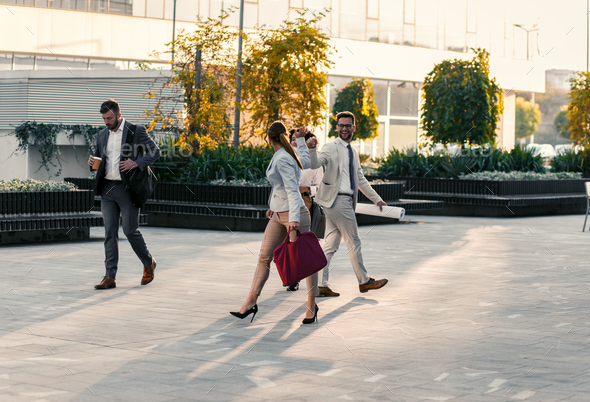 Group of business people walking outside in front of office buildings ...