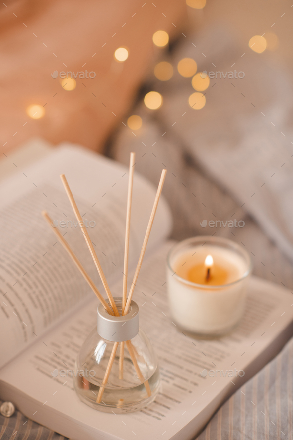 Home liquid diffuser with fragrance with candle and open book in ...