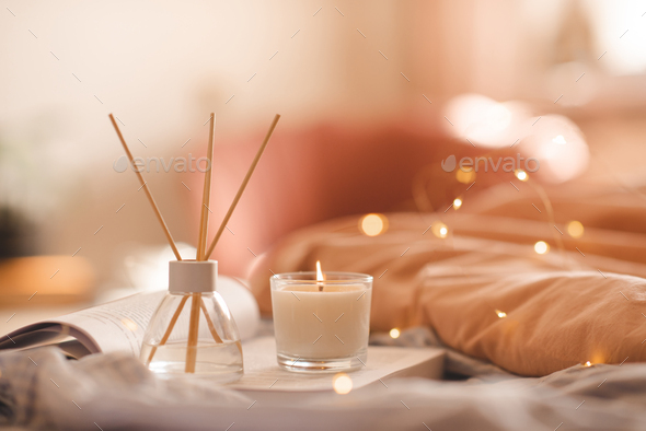 Home liquid diffuser with fragrance with candle and open book in ...