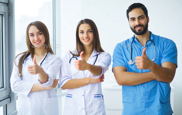 Portrait of medical team standing with arms crossed in hospital Stock Photo by maksymiv