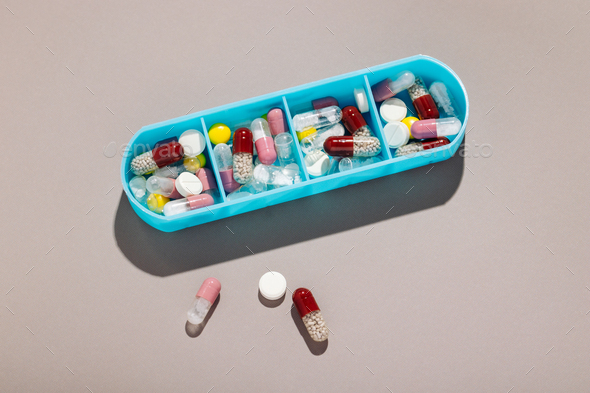 Blue pill box with medicines on a gray background Stock Photo by lyalya_go