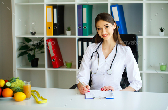 Beautiful Young Dietitian Smiles and Works in Light and Modern Office ...