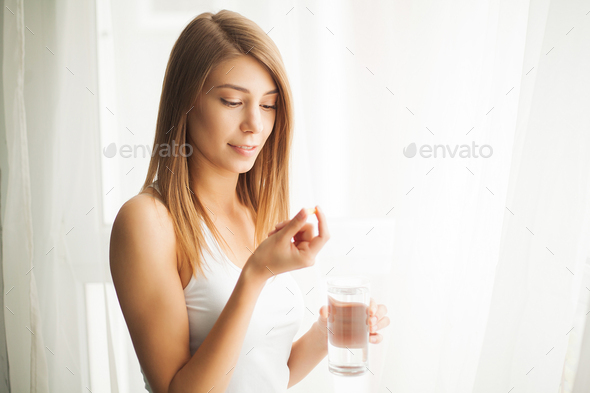 Vitamins and Supplements. Woman taking a tablet. Close up hand with a ...