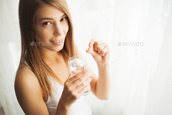Vitamins and Supplements. Woman taking a tablet. Close up hand with a ...