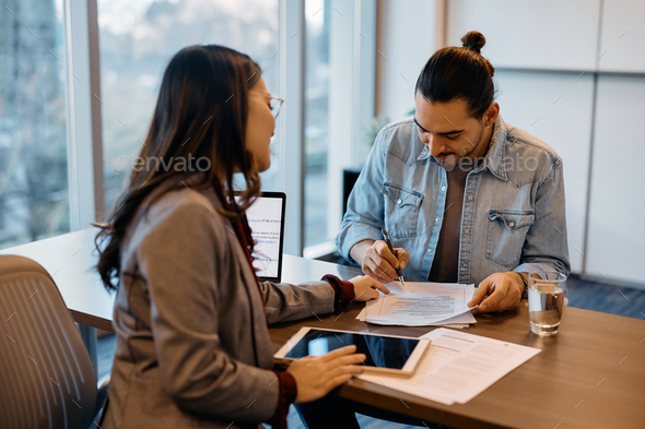 Happy candidate signing a contract during job interview in the office ...