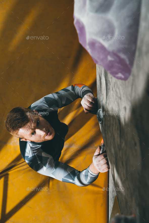 High angle shot of young man in sport attire, prepared to climb a wall ...