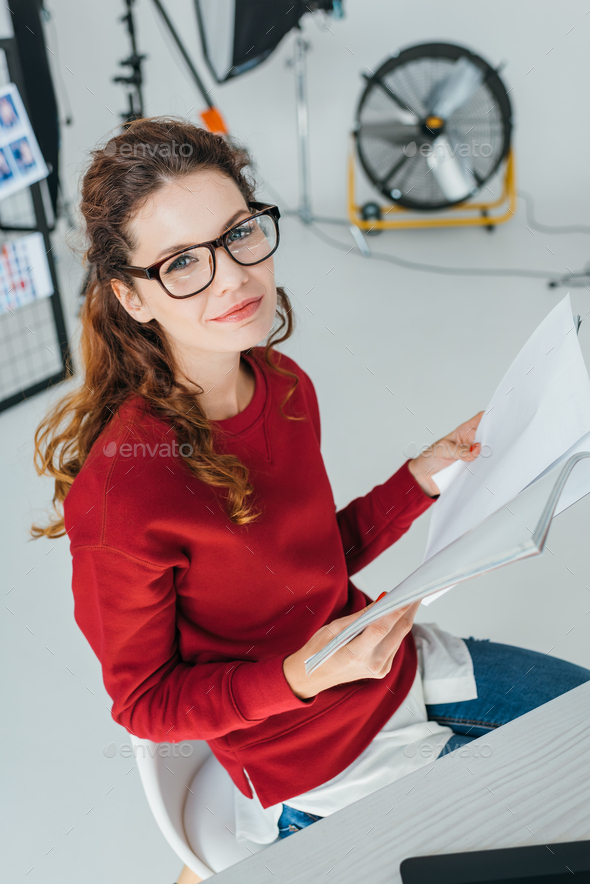 beautiful female designer reading magazine in modern office Stock Photo ...