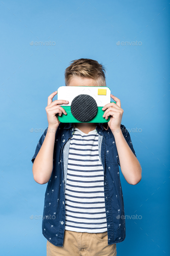 cute little boy photographing with papercraft camera isolated on blue ...