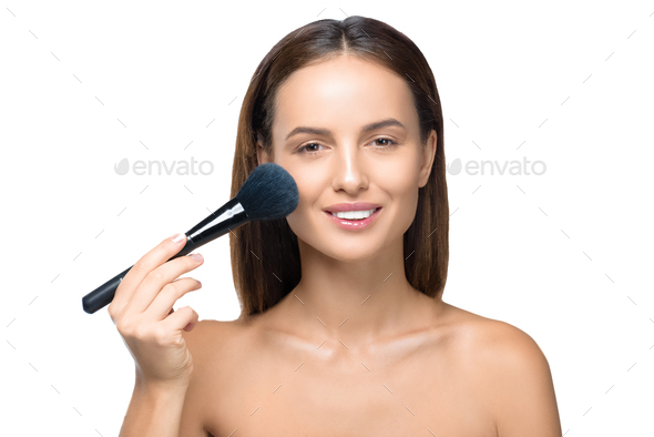 Beautiful Naked Girl Applying Makeup With Brush And Smiling At Camera Isolated On White Stock