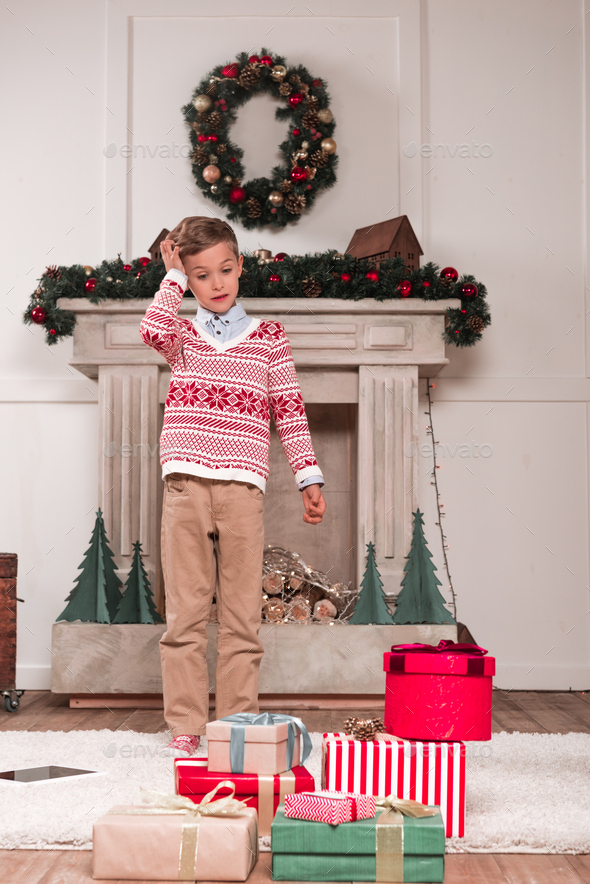 surprised boy looking at heap of gifts laying on floor Stock Photo by ...