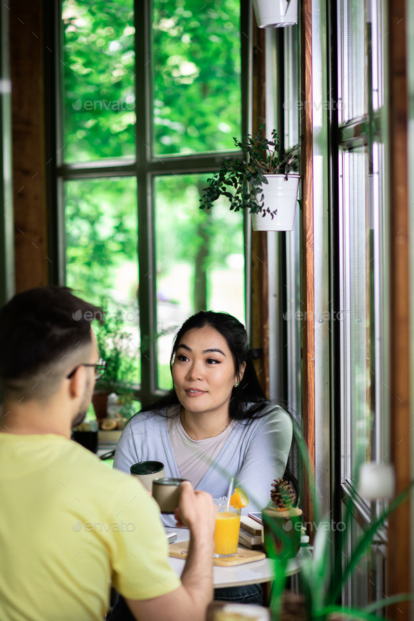 Couple sitting in a coffee shop talking and drinking coffee. Stock ...