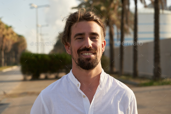 Cheerful photo of a handsome caucasian young man with long blond hair ...