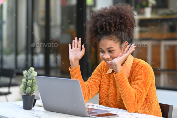 Cheerful American African woman sitting outdoor talking to colleagues ...
