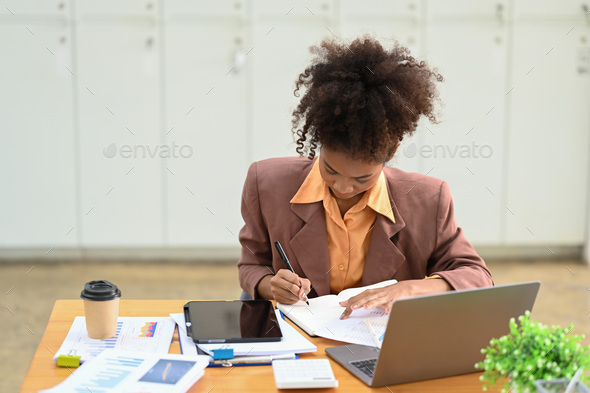 Focused female accountant comparing corporate income for previous year ...