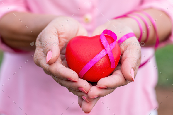Purple gender equality ribbon wrapped around hands and a heart held by ...