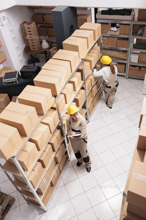Retail store warehouse workers packing boxes and supervising inventory ...