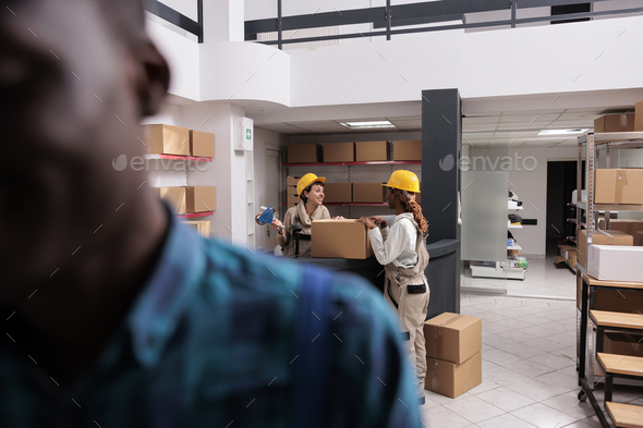 Shipping department managers packing client order with sticky tape ...