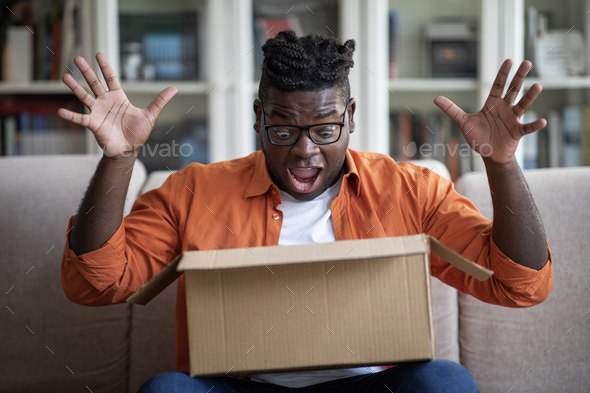 Excited fat african man customer receive good parcel, opening delivery ...