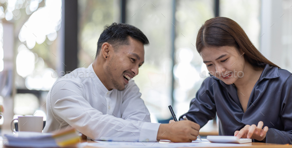 Two Asian business colleagues working together on new project in ...