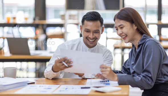 Two Asian business colleagues working together on new project in ...