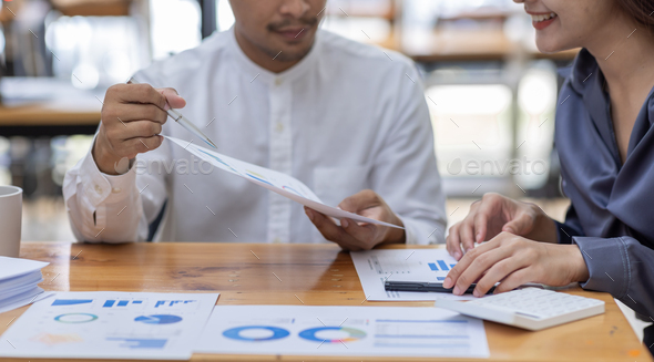 Two Asian business colleagues working together on new project in ...