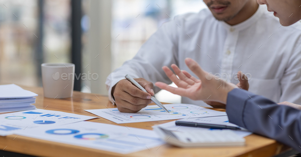 Two Asian business colleagues working together on new project in ...