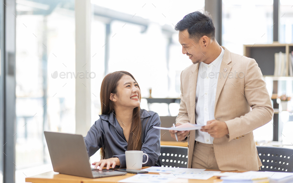 Two Asian business colleagues working together on new project in ...