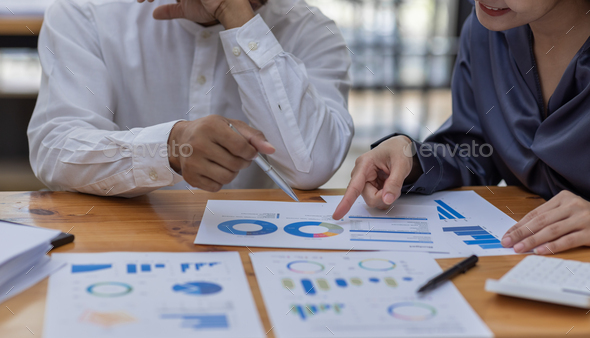 Two Asian business colleagues working together on new project in ...