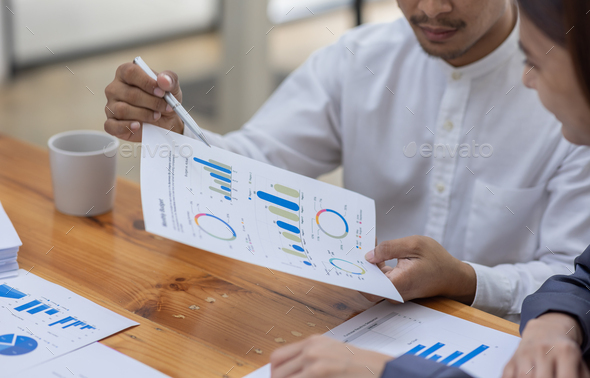 Two Asian business colleagues working together on new project in ...