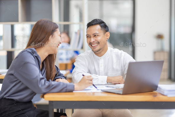 Two Asian business colleagues working together on new project in ...