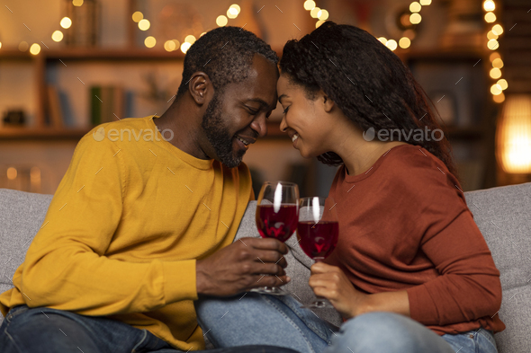 Romantic african american lovers cuddling on couch at home Stock Photo ...
