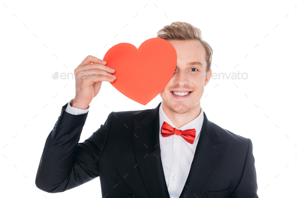 stylish man holding heart symbol and smiling at camera isolated on ...