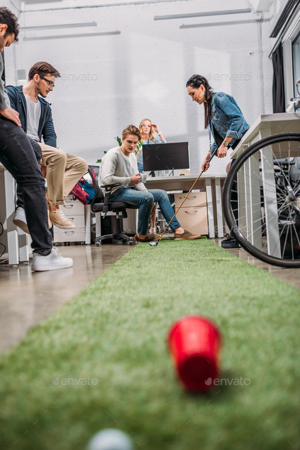 cheerful colleagues playing in mini golf at modern office Stock Photo ...