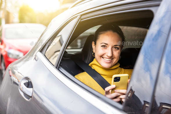 Happy woman portrait sitting on the back seat of a taxi car in the city ...