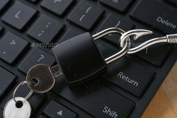 Lock on fishing hook on computer keyboard, concept fraud phishing scam ...