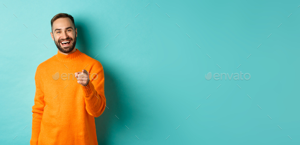 Handsome man laughing and pointing at camera, nodding in approval ...