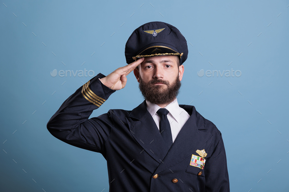 Serious aviation academy airplane pilot saluting Stock Photo by DC_Studio