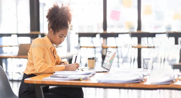 Black Businesswoman Sitting at Her Desk Working on a Laptop Computer ...