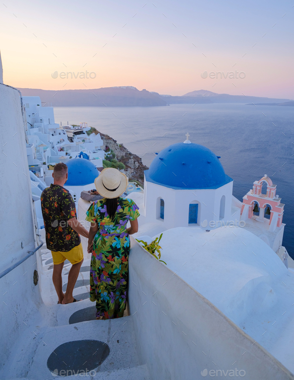 Couple walking at the Greek village of Oia Santorini Greece, men and ...